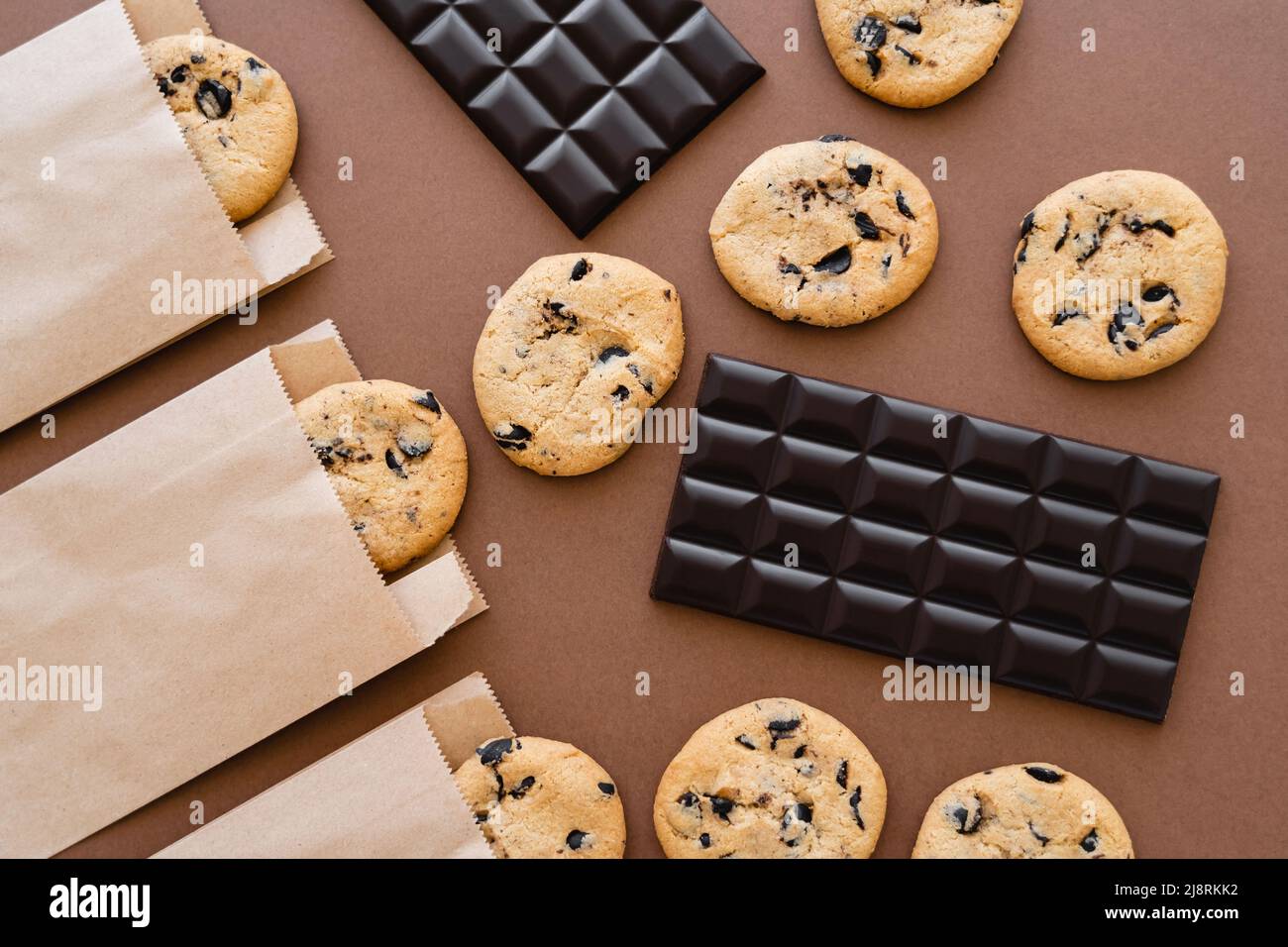Top view of chocolate bars and cookies in craft packages on brown ...