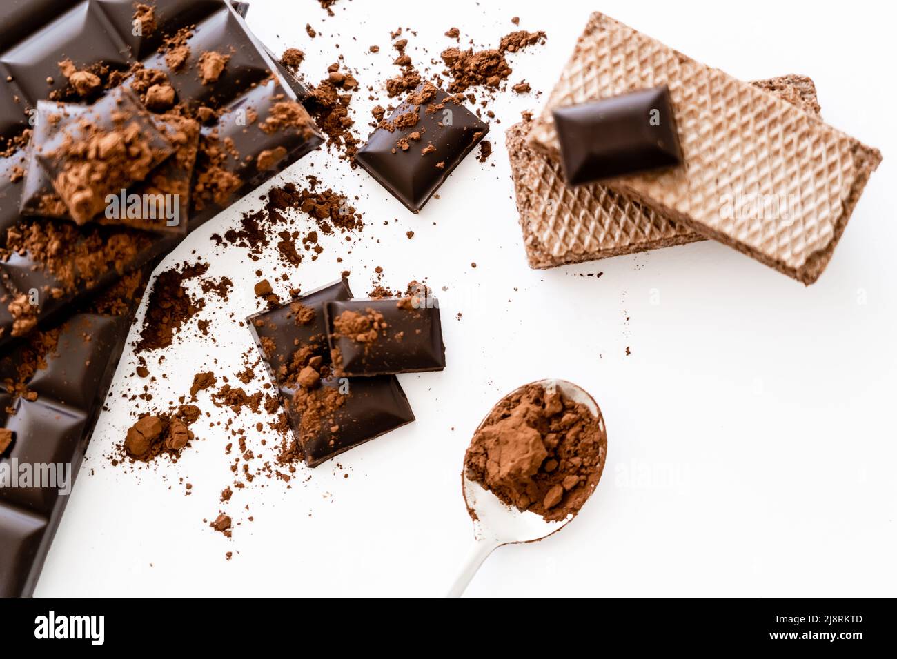 Top view of cocoa in spoon, chocolate bars and waffles on white background Stock Photo - Alamy