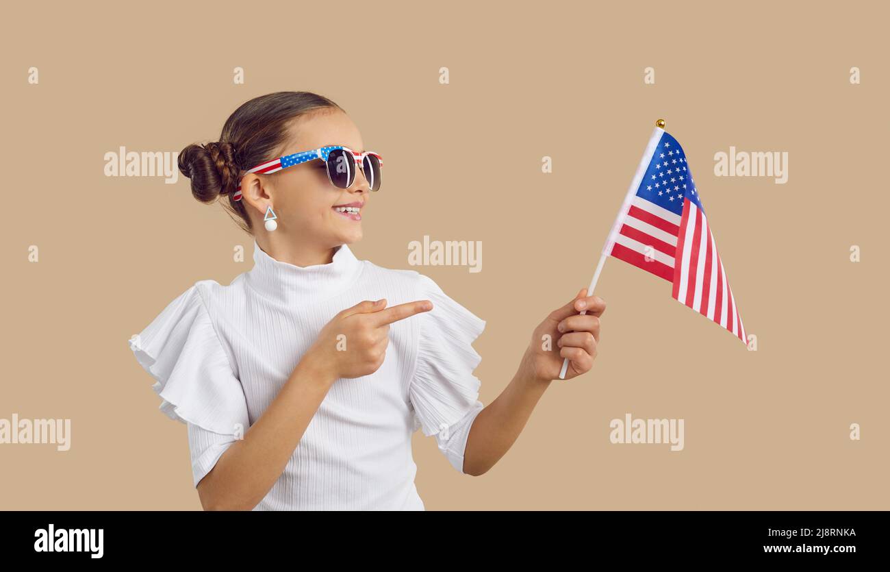 Preteen kid wearing patriotic accessories and holding US flag ...