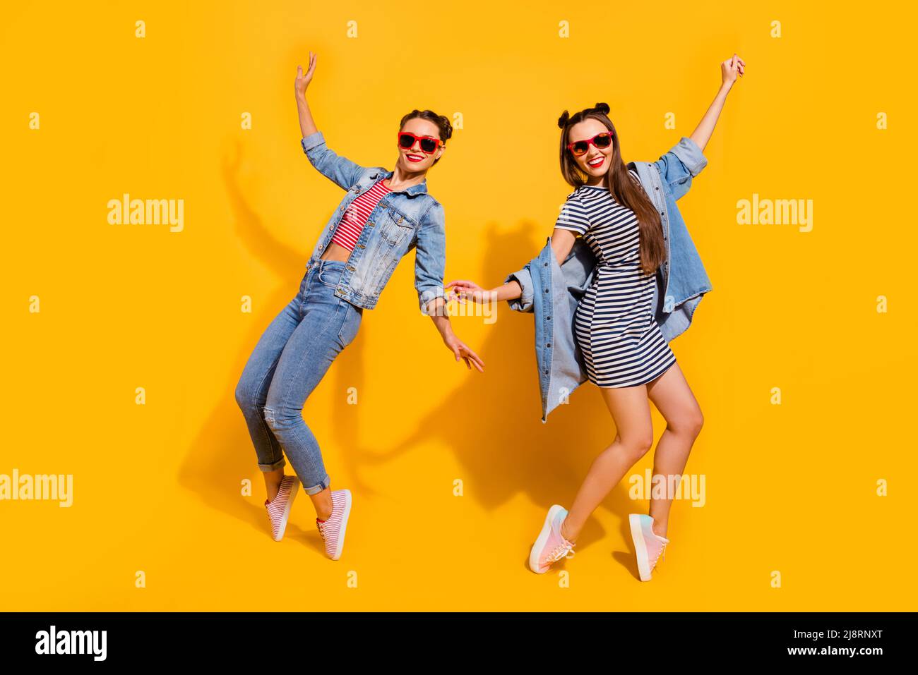 Full length portrait of two overjoyed active ladies enjoy dancing ...