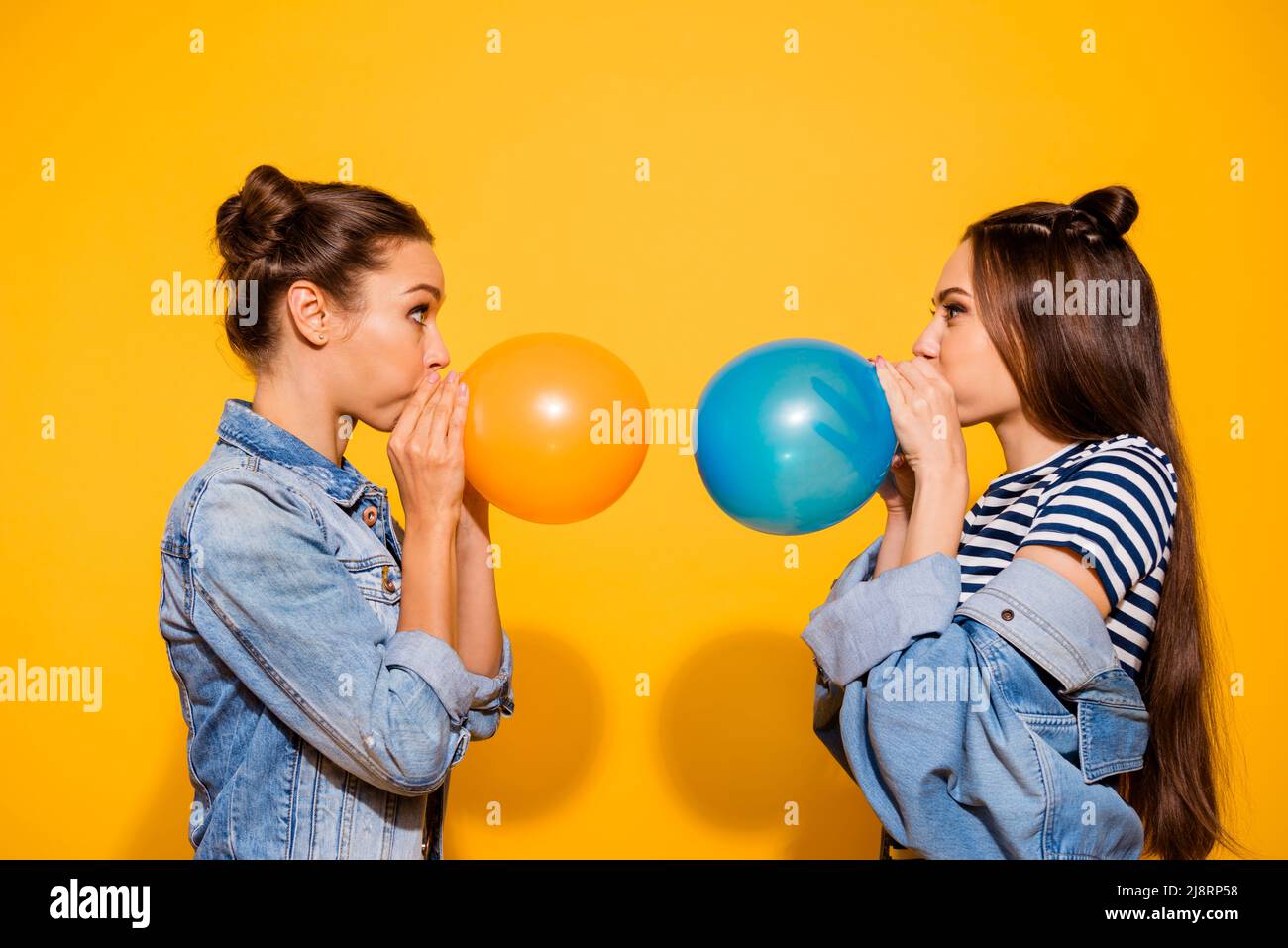 Profile photo of two funky positive people blowing balloon look each ...