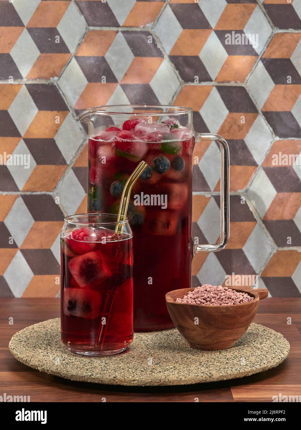 A jug and a glass of iced fruit tea made from instant tea granules ...