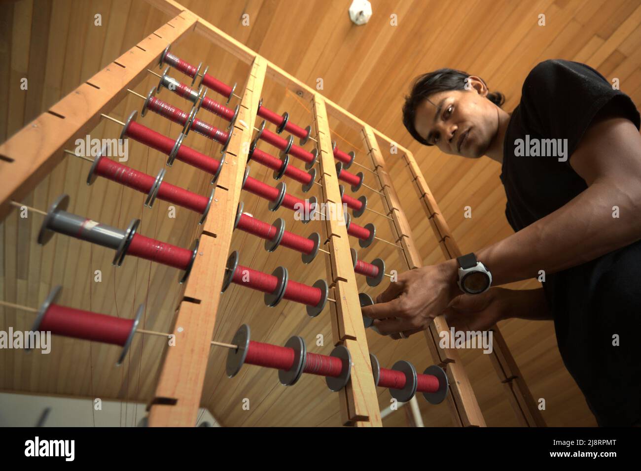 A worker organizing songket yarns at Erika Rianti songket studio in ...