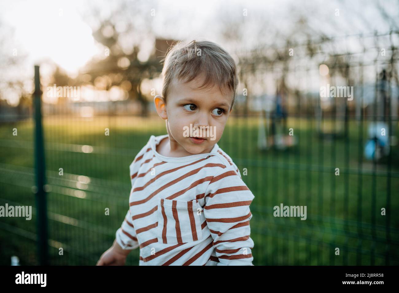Little boy looking away outside in park Stock Photo - Alamy