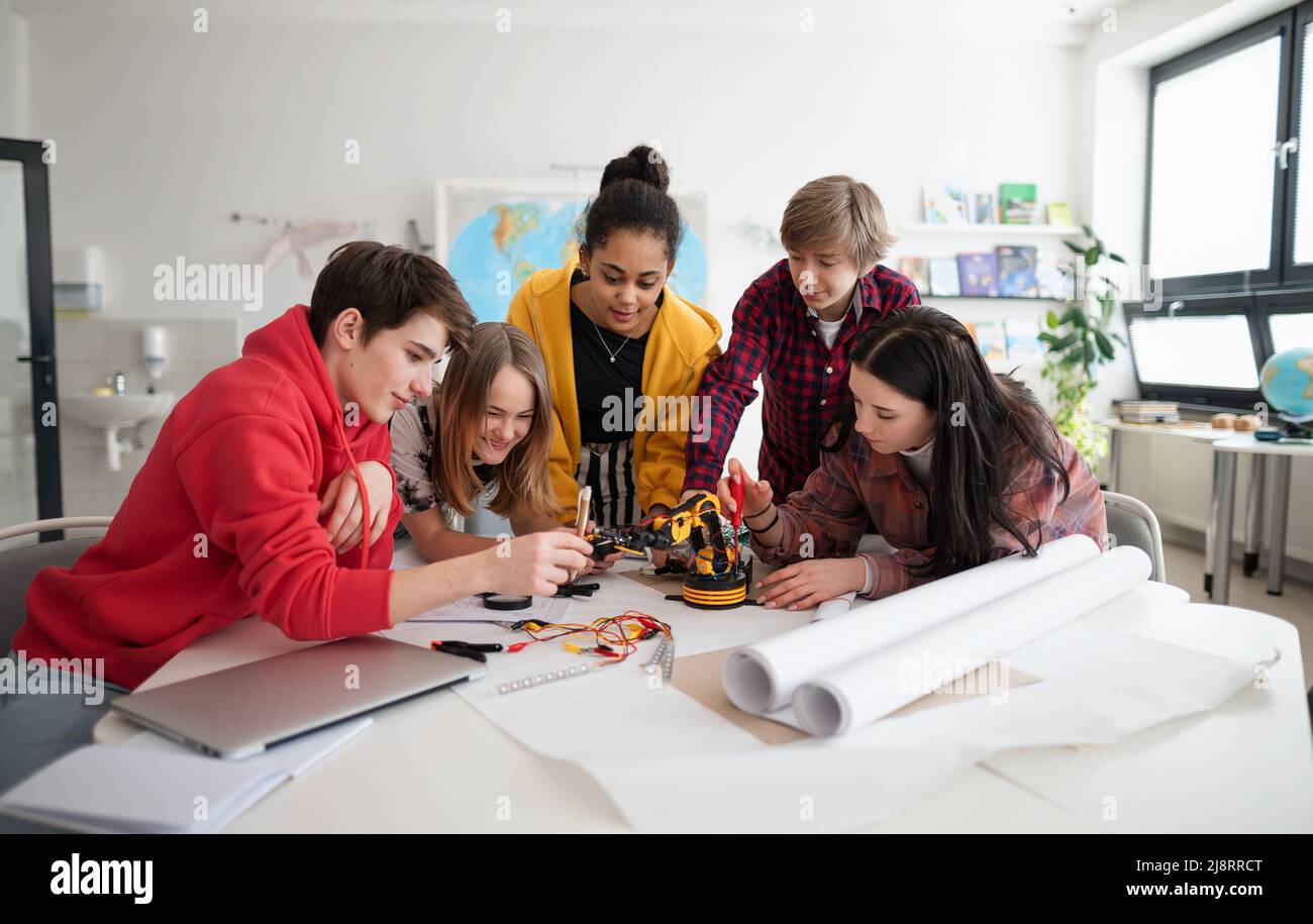 Group of students building and programming electric toys and robots at ...