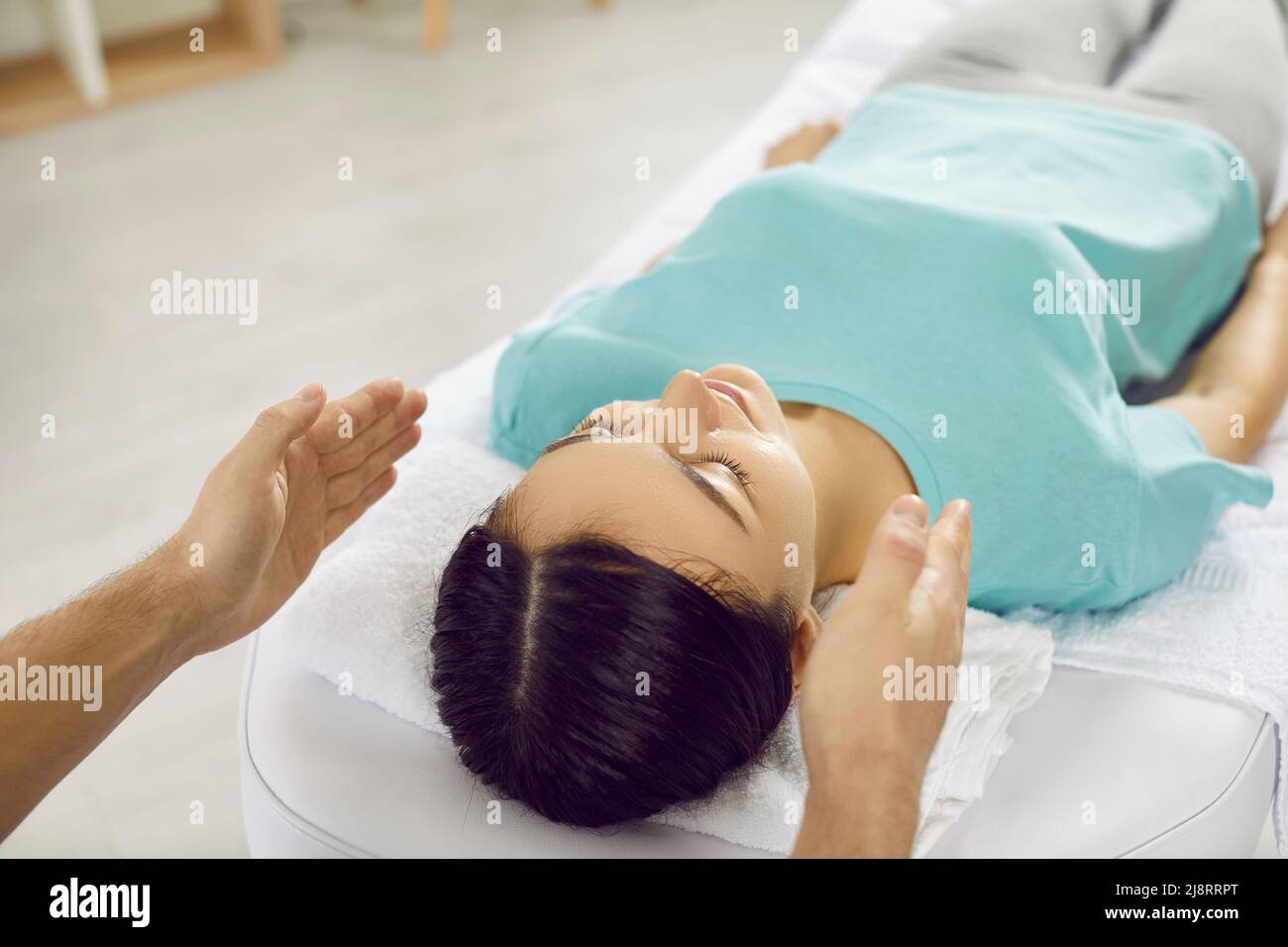 Woman undergoes alternative therapy during reiki session in modern ...