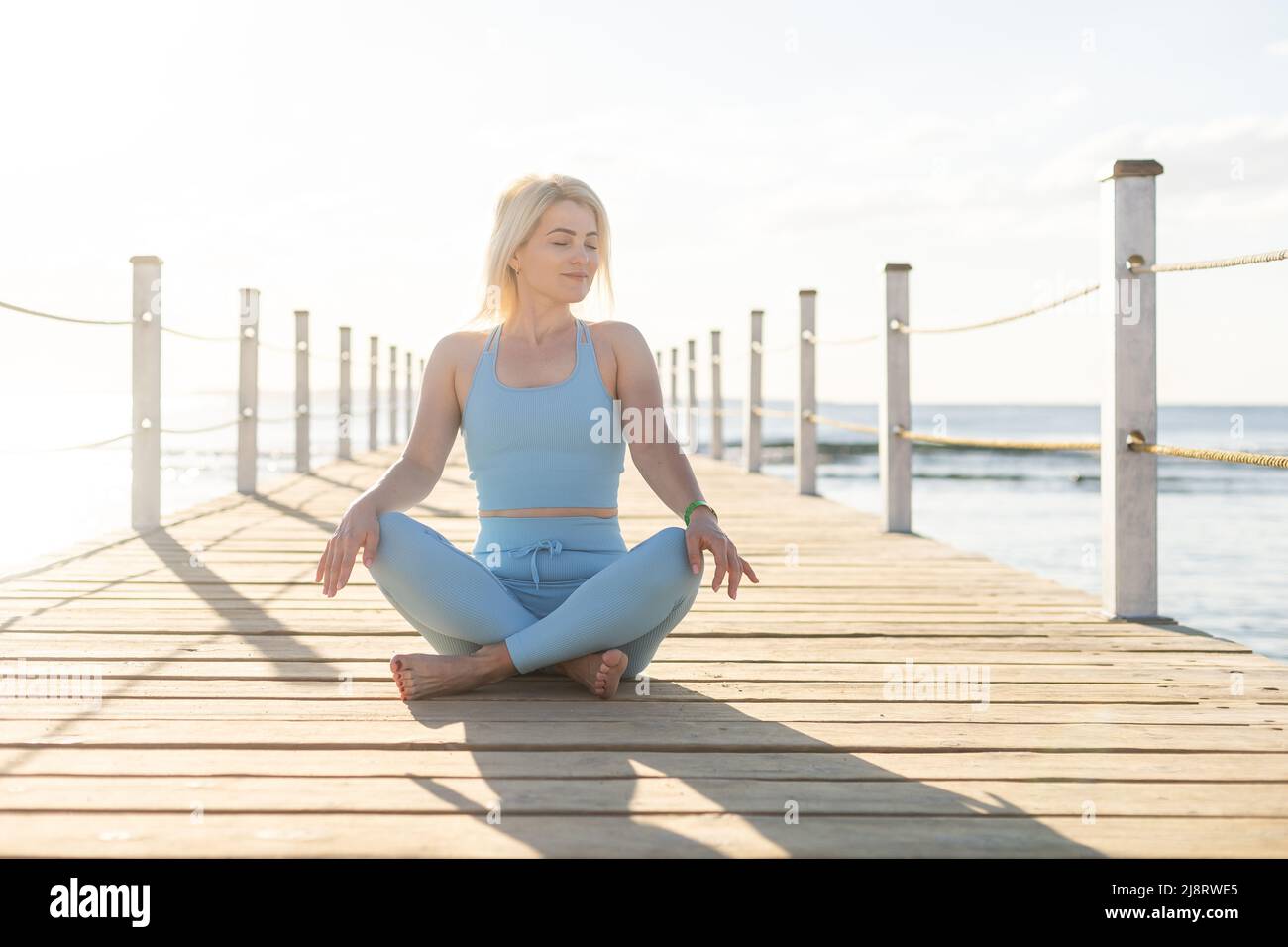 Woman doing yoga exercises by the sea Stock Photo - Alamy