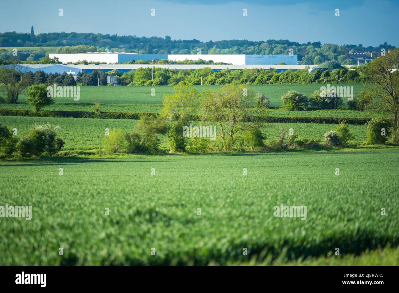 new built distribution warehouse building with farm fields in ...