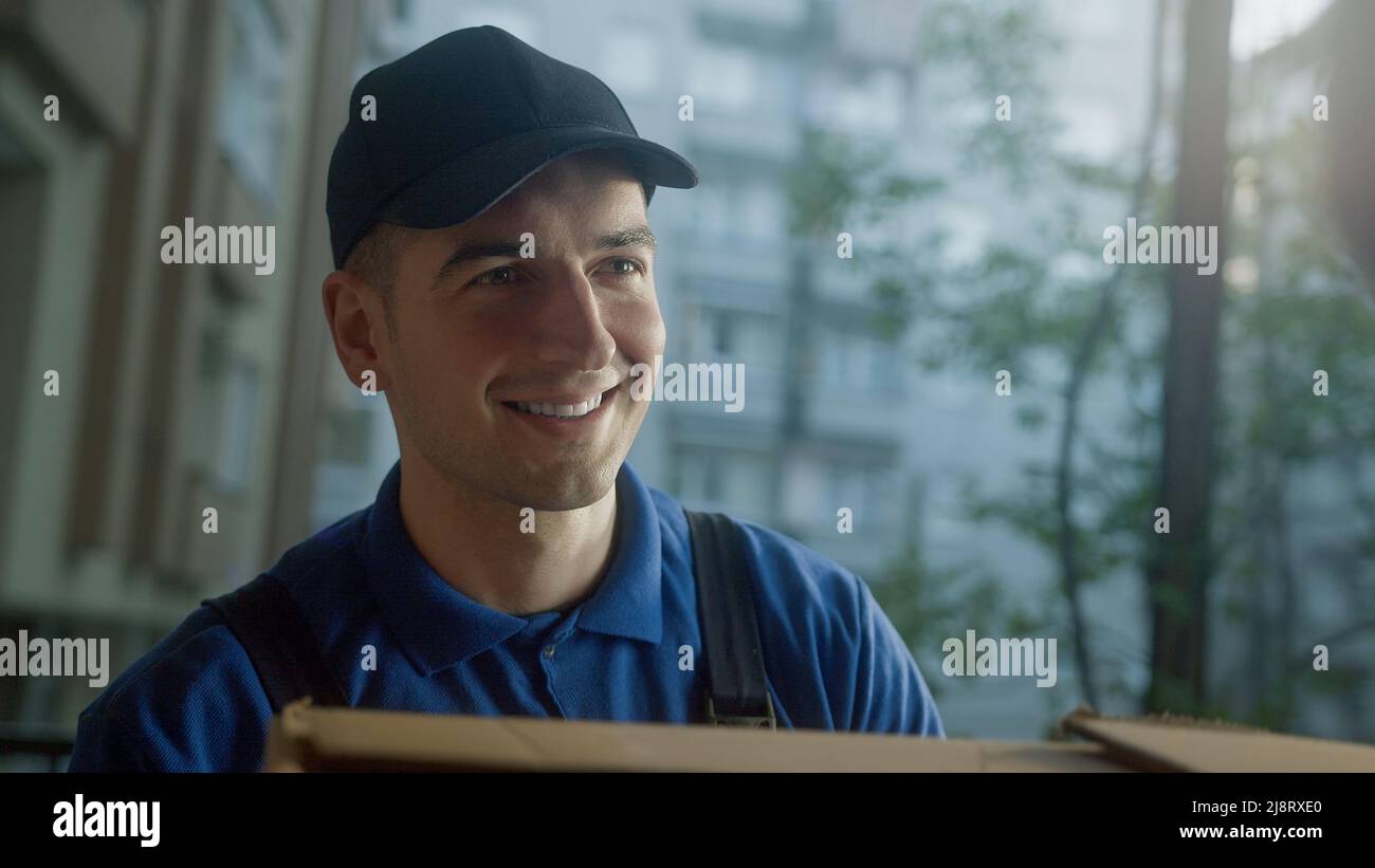 Young delivery courier man in blue shirt handling parcel boxes for ...