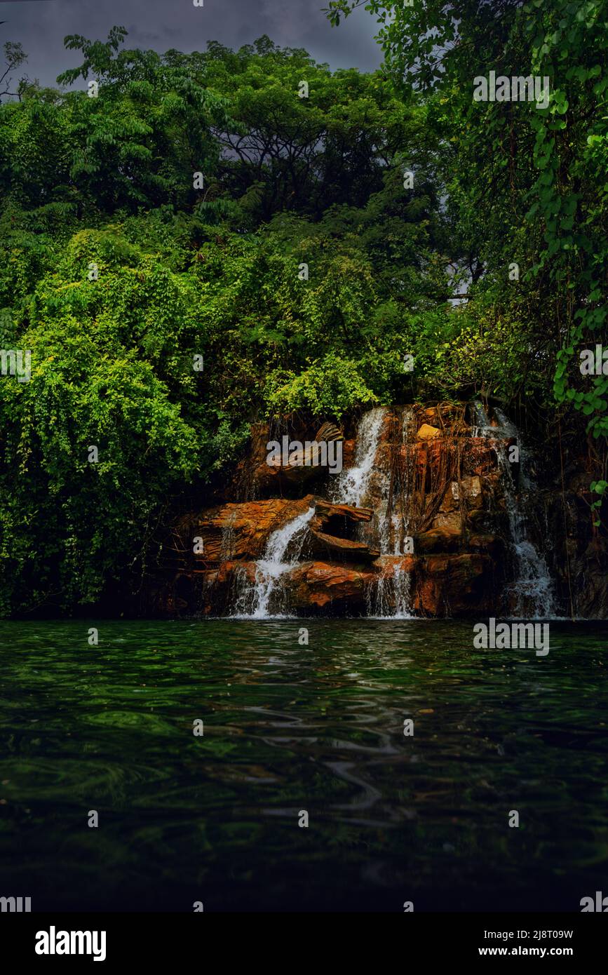 Beautiful dramatic small waterfall, a big part of pond and ripple on ...