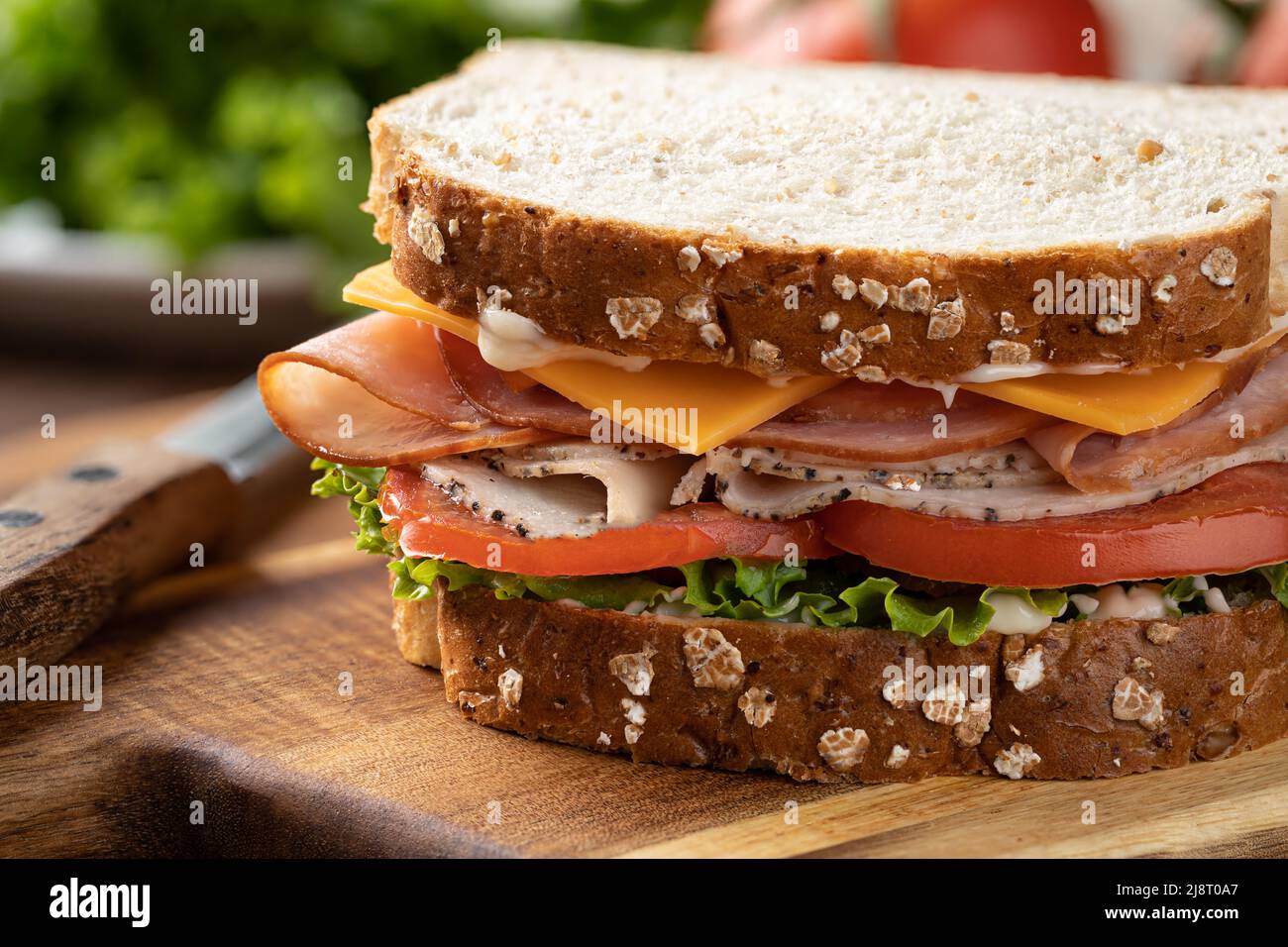Closeup of sandwich made with turkey, ham, cheese, lettuce and tomato ...