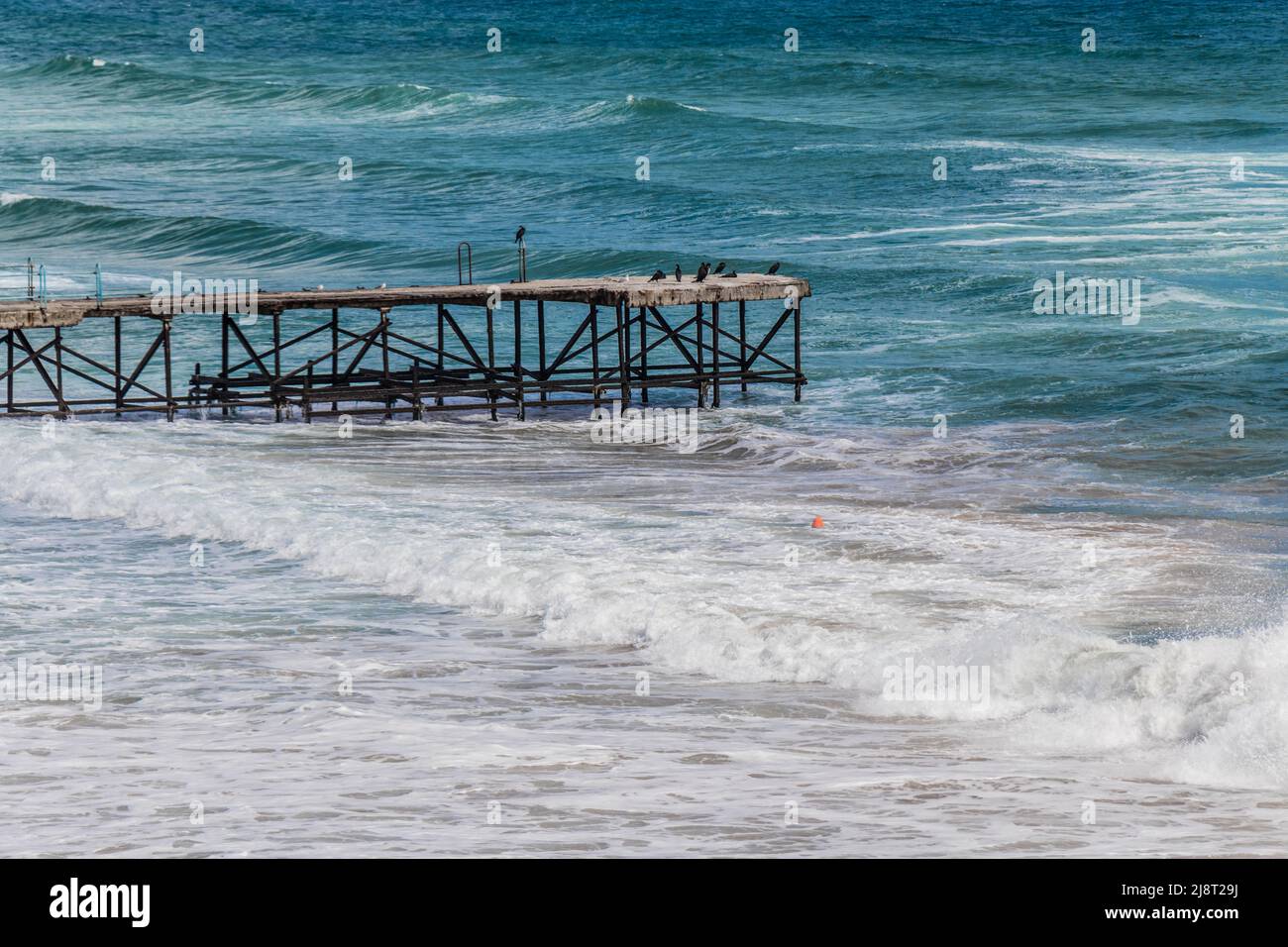 Old, abandoned jetty rotting away over the sea Stock Photo - Alamy