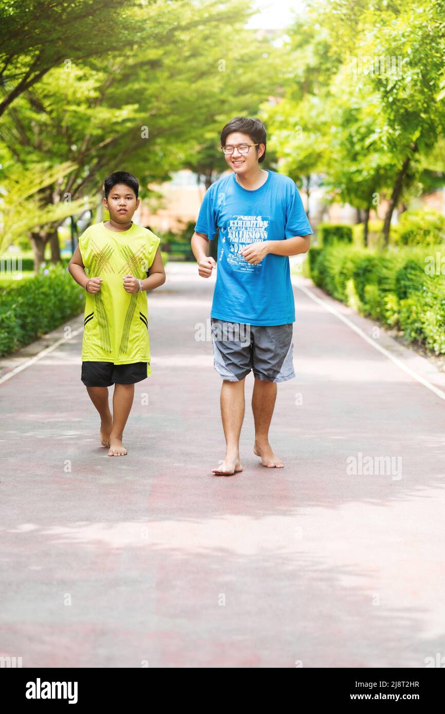 Asian couple of brother run together in park Stock Photo - Alamy