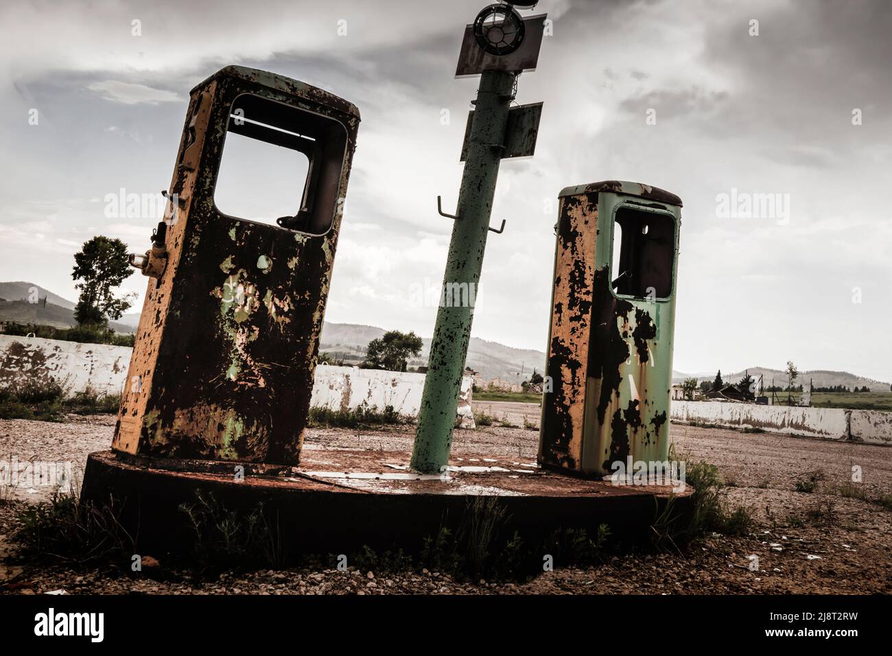 the destroyed rusty gas station against the background of the gloomy ...