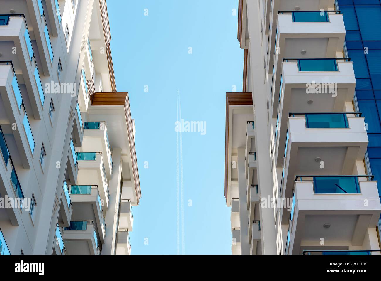 View between the buildings on the sky with a plane flying by Stock ...