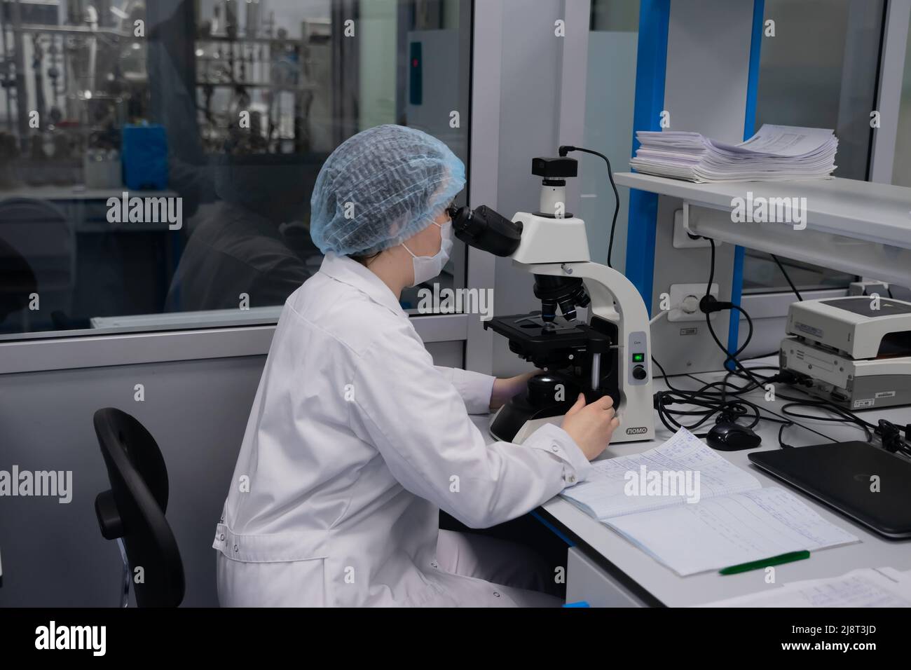 Kazan, Russia. May 10, 2022. Researcher looking through microscope in ...