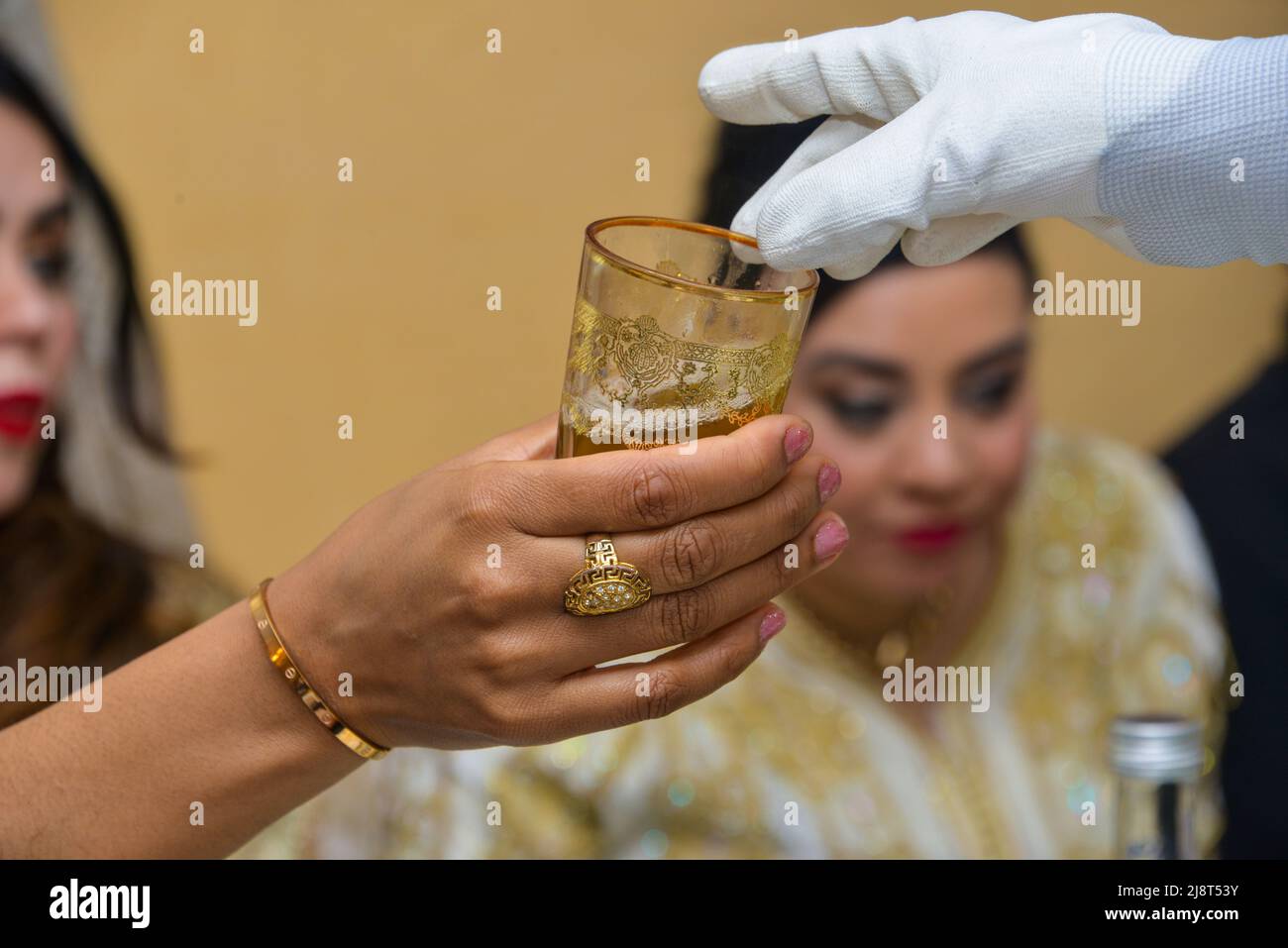 Serve Moroccan tea to the guests. The waitress serves tea to the ...