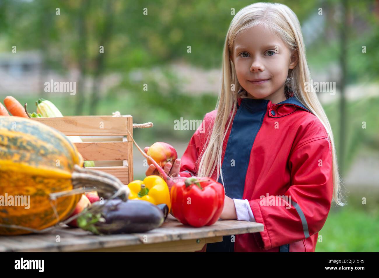 Long-haired blonde girl looking busy while sorting veggies Stock Photo ...