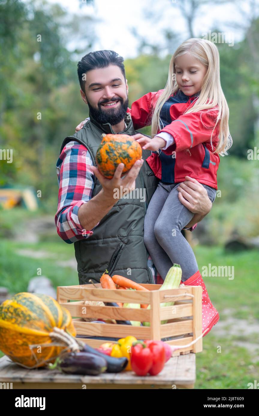 Dad and daughter spending time on a farm sorting the vegetables Stock ...