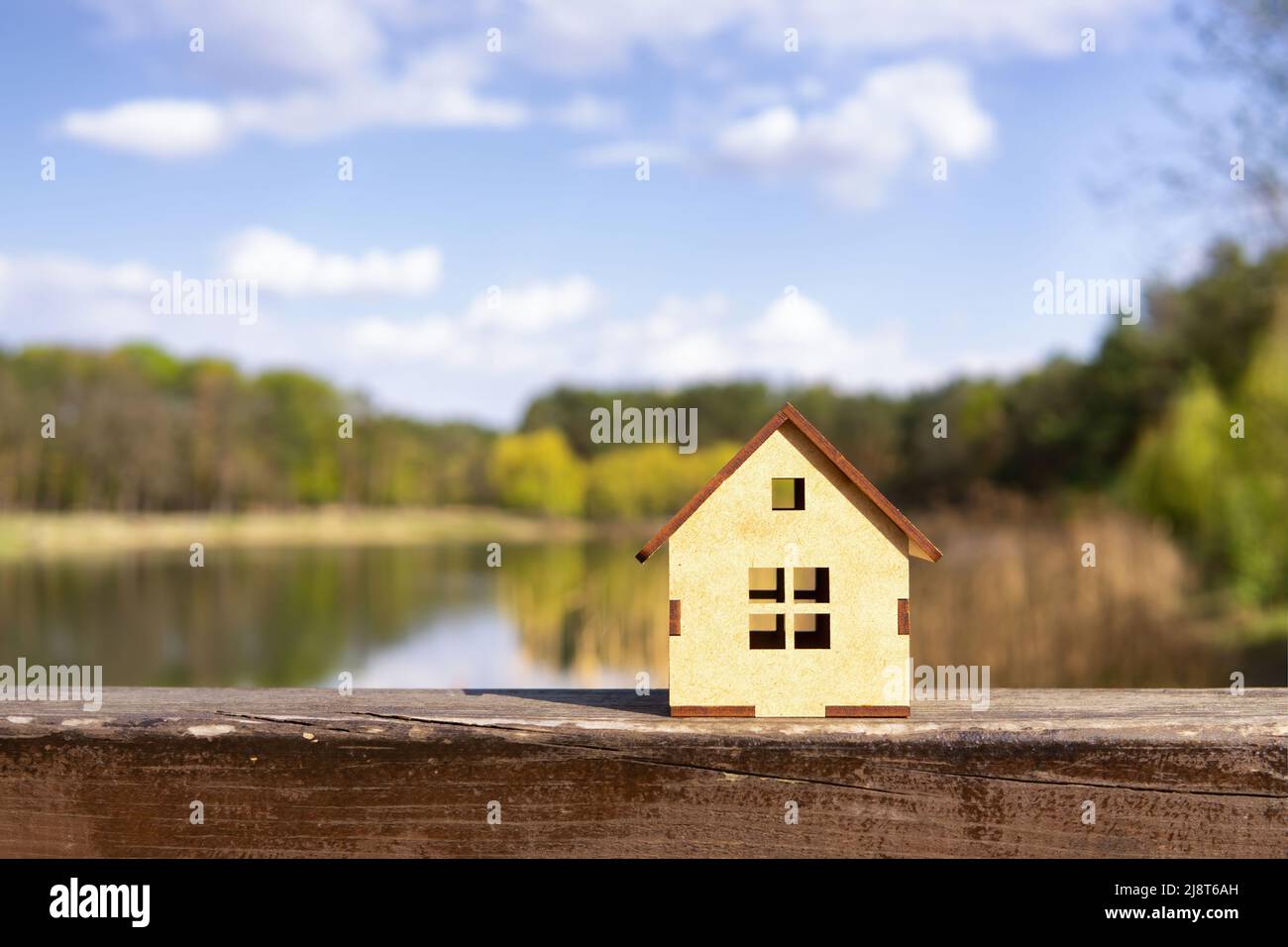 Miniature wooden house model by a lake with a beautiful landscape ...