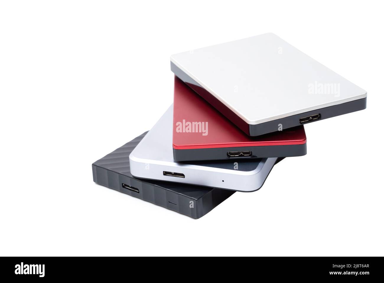Pile of four external portable hard disk drives isolated on white ...