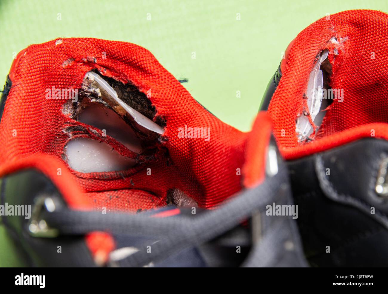 Old worn out ripped sneakers. Torn back in shoes, close-up. Shoe repair ...