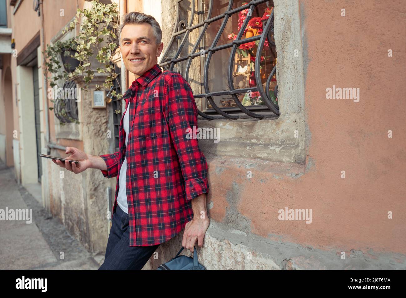 Man leaning on building looking away Stock Photo - Alamy