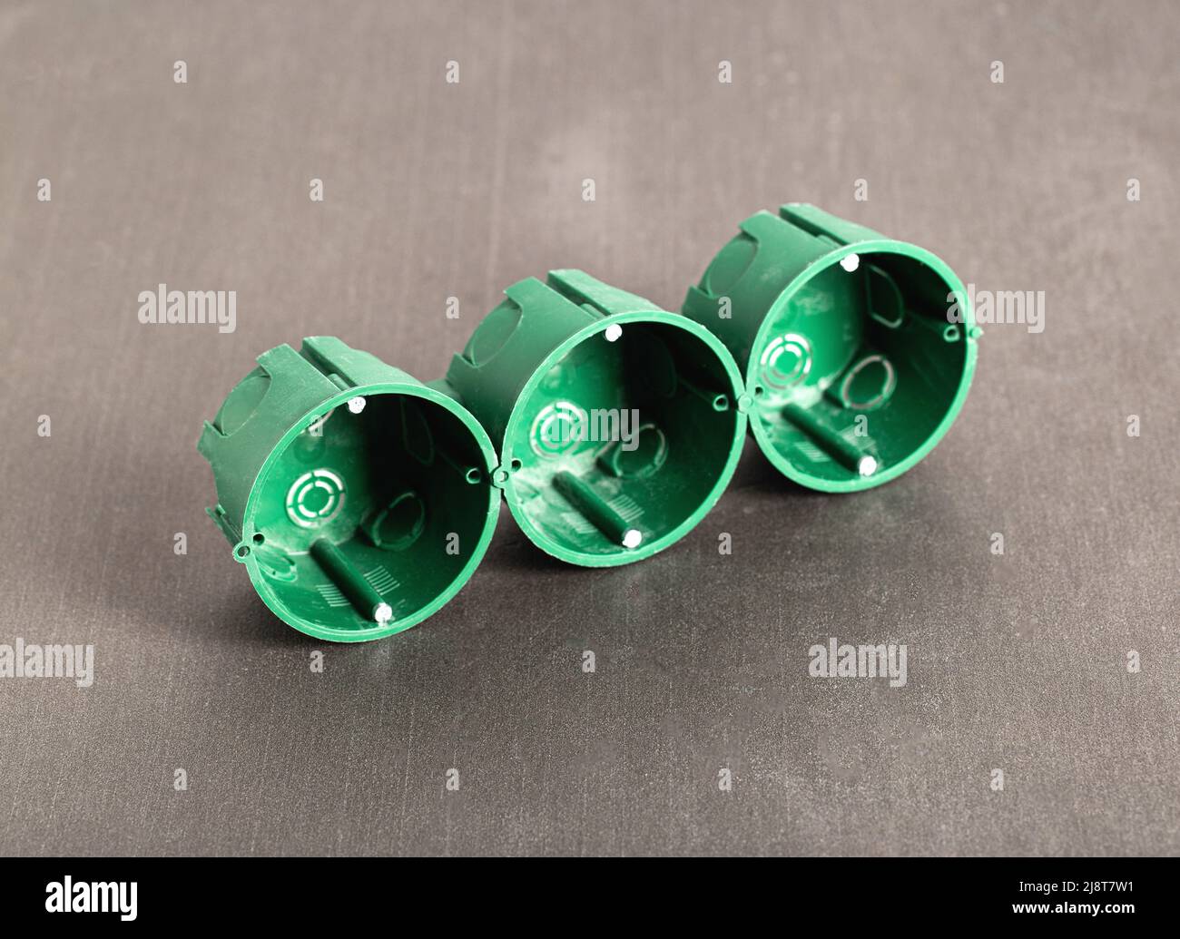 Green socket boxes for installation in concrete walls on a gray ...