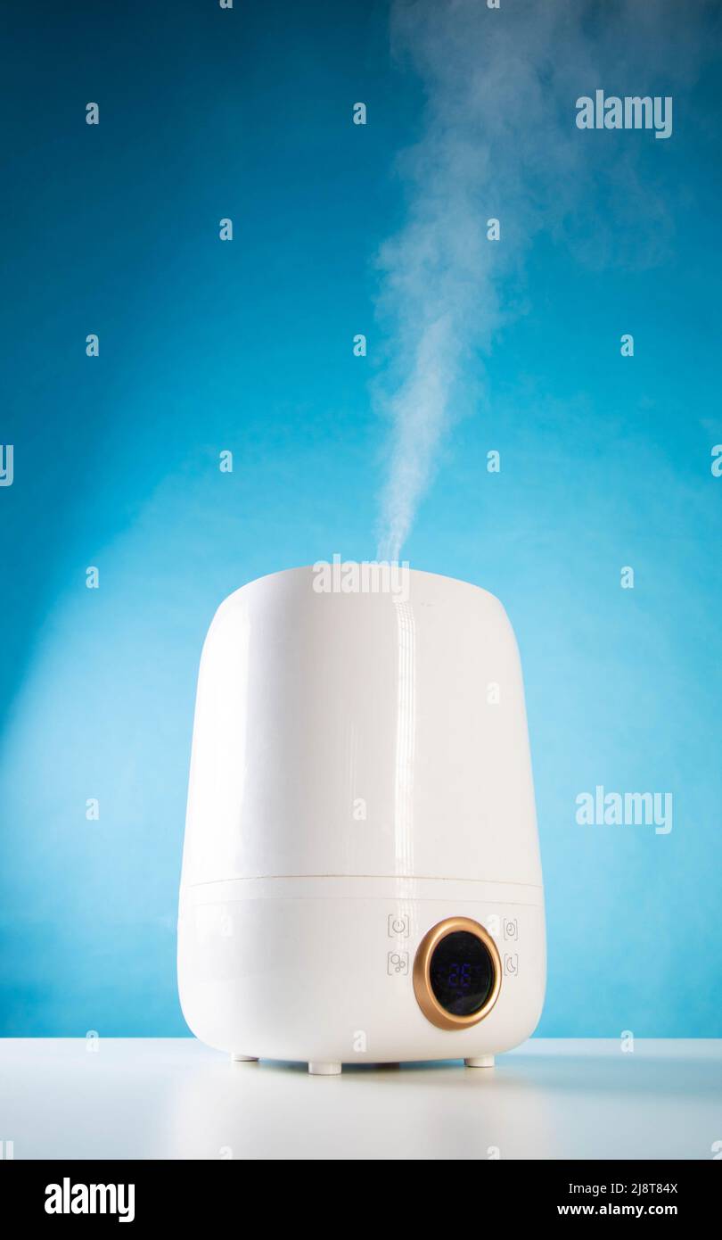 Modern air humidifier on a blue background. Humidification in the room ...