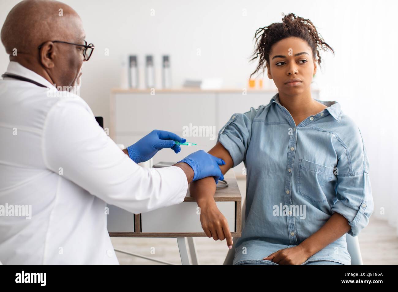 Black Woman Receiving Vaccine Injection Sitting With Doctor Indoor ...