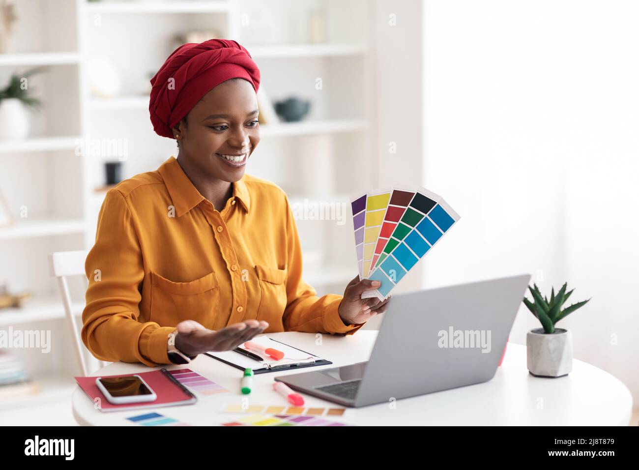 Cheerful african american muslim lady designer having video conference ...