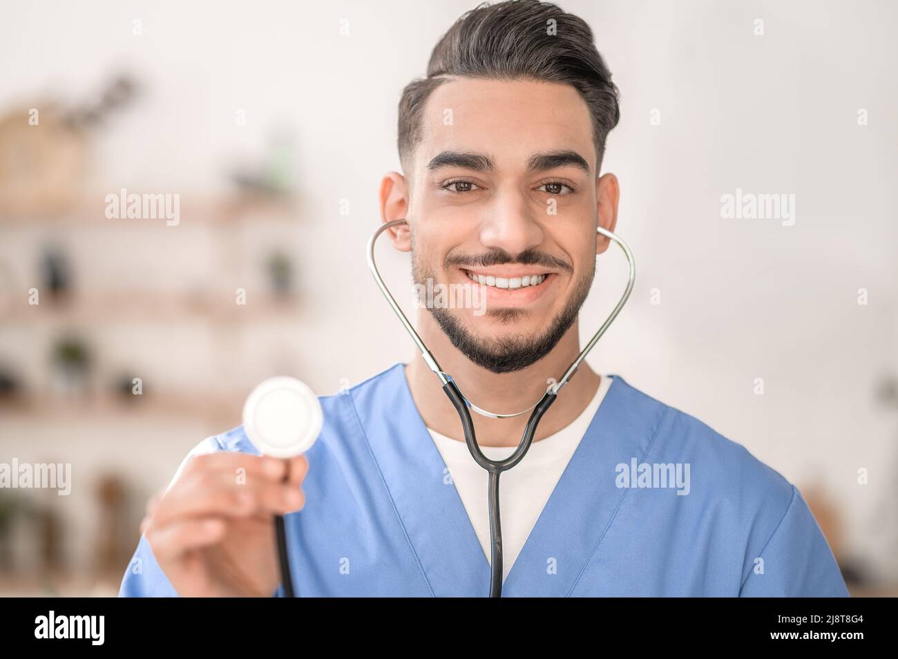 Joyful male physician showing his medical instrument Stock Photo - Alamy