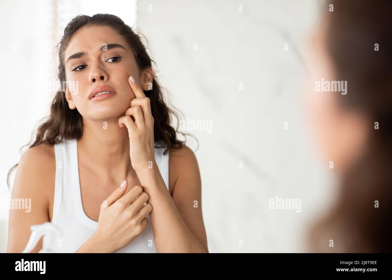 Depressed Woman Touching Pimple On Face In Modern Bathroom Stock Photo ...