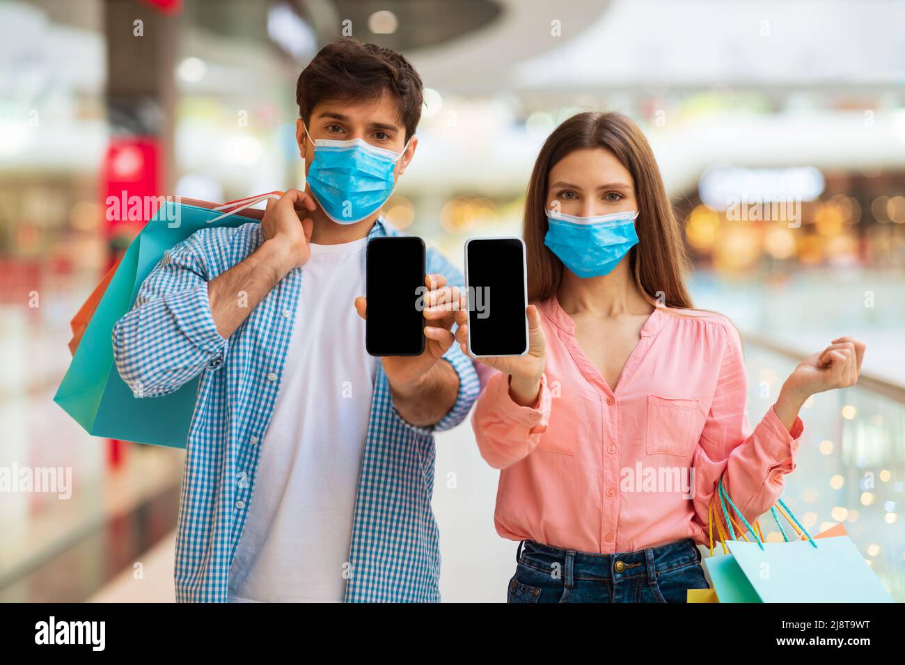 Couple Advertising Mobile Shopping Application Showing Cellphones In ...