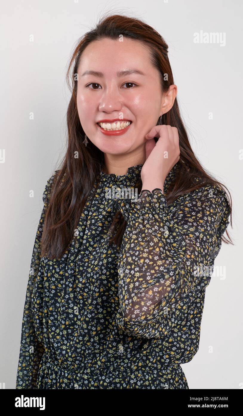 Young Hong Kong Chinese woman wearing long-sleeved patterned dress ...