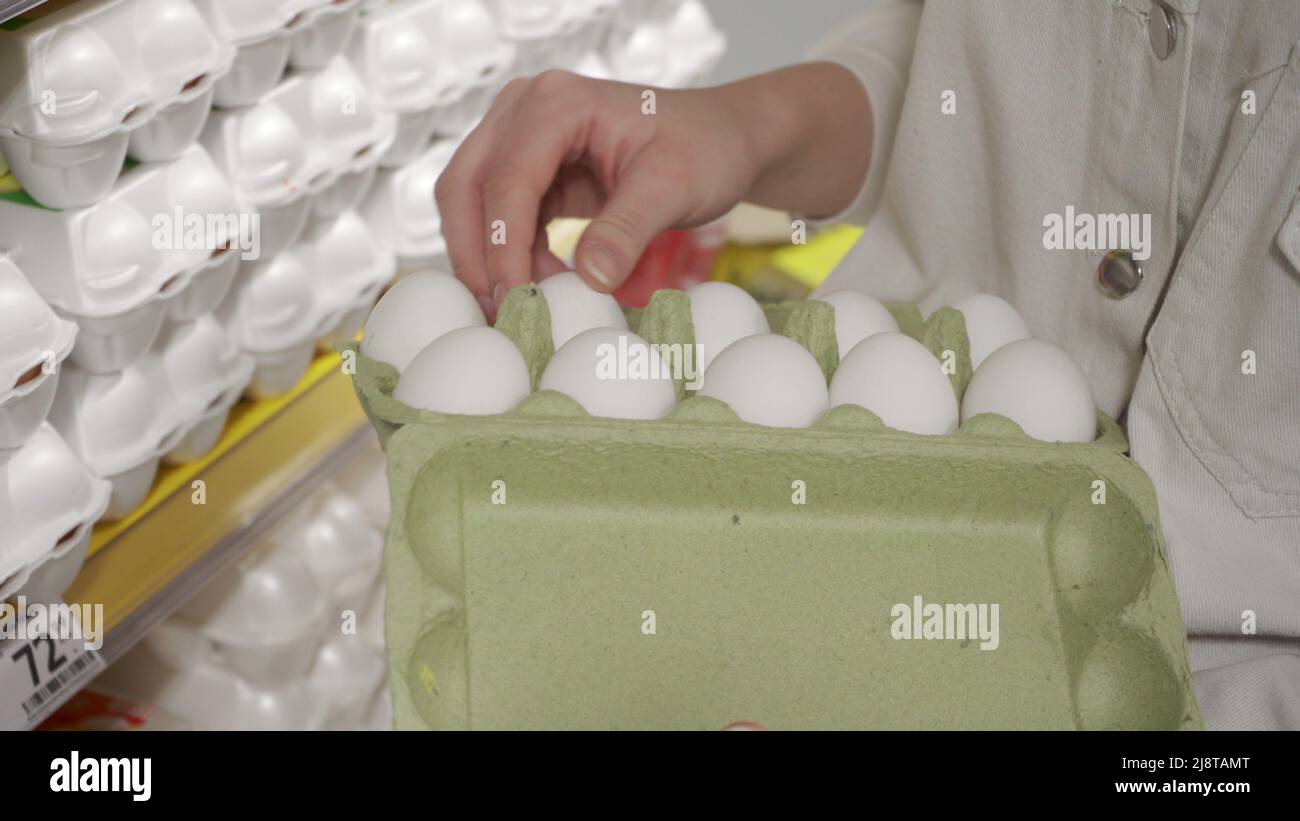 In the hands of a woman packing eggs in the supermarket Stock Photo - Alamy