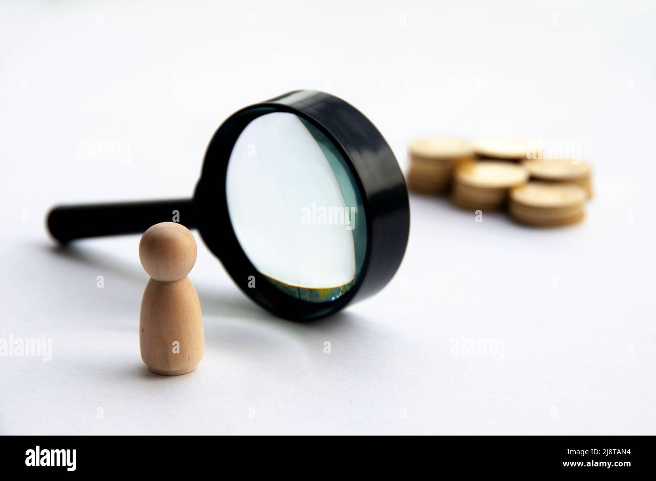 Wooden doll looking through magnifying glass for wealth. Business ...
