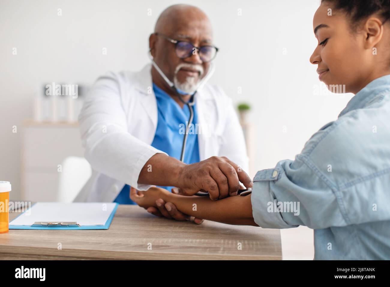 Black male doctor checking measuring pressure on patient's hand Stock ...