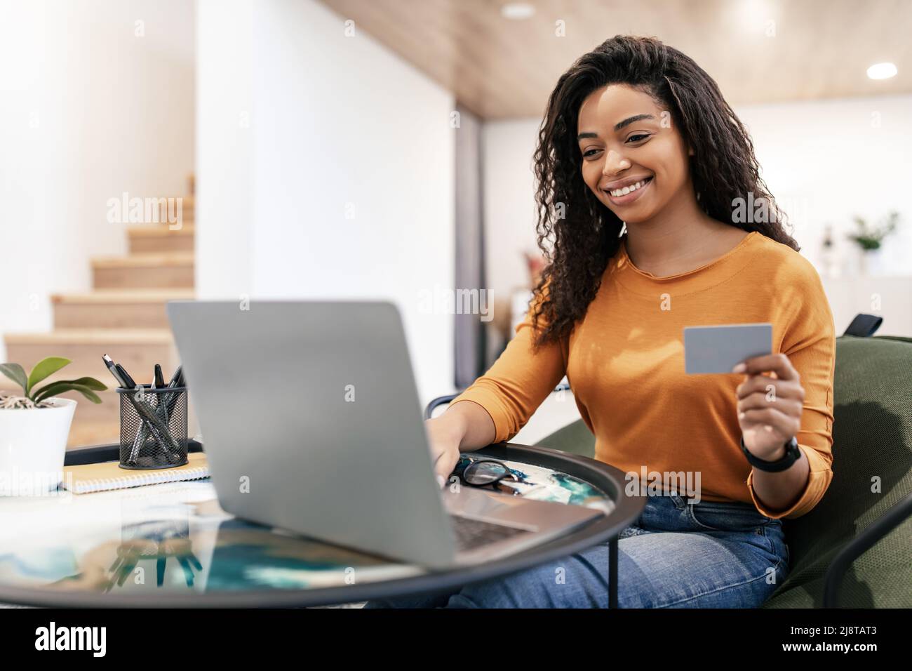 Happy woman holding debit credit card, using computer Stock Photo - Alamy