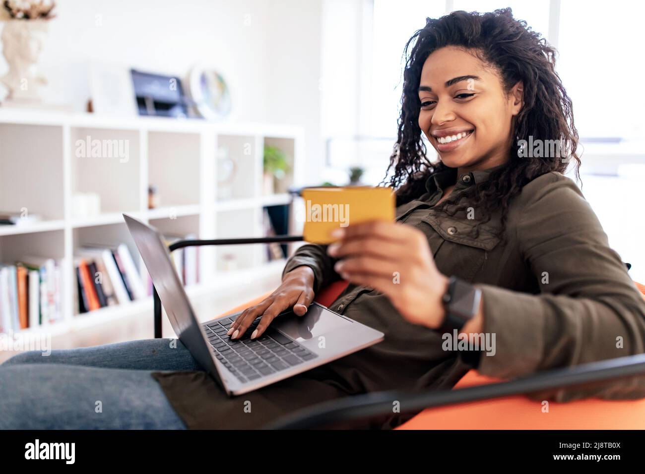 Happy woman holding debit credit card, using laptop pc Stock Photo - Alamy