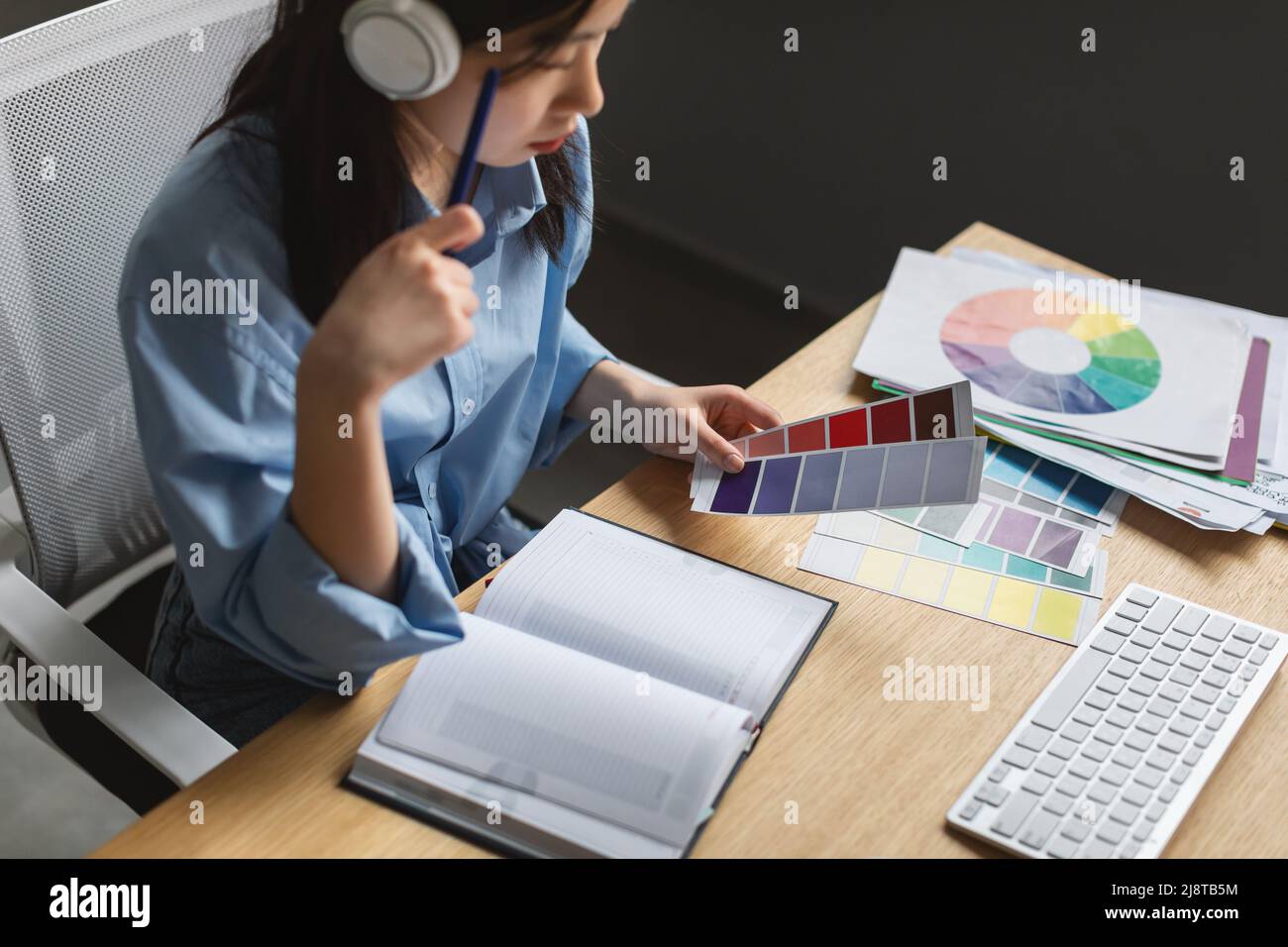 Portrait Of Female Asian Designer Writing In Notebook Stock Photo - Alamy
