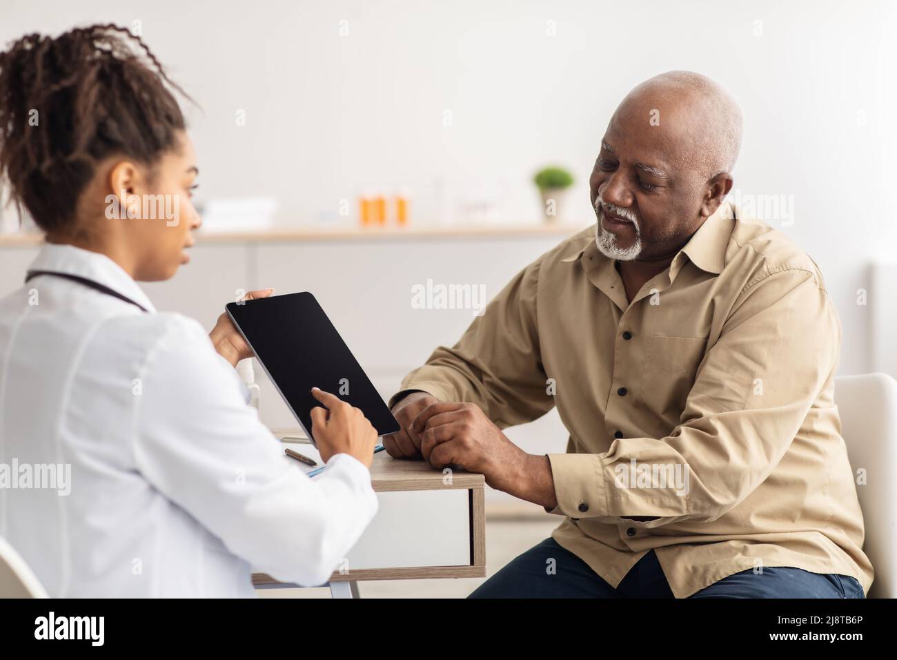 Young black doctor explaining treatment plan to male patient Stock ...