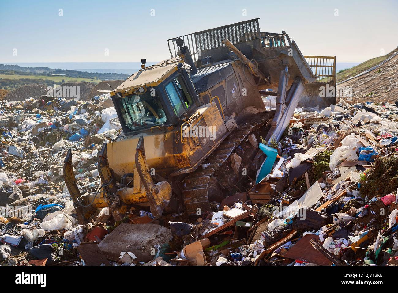 Heavy machinery shredding garbage in an open air landfill. Waste Stock ...