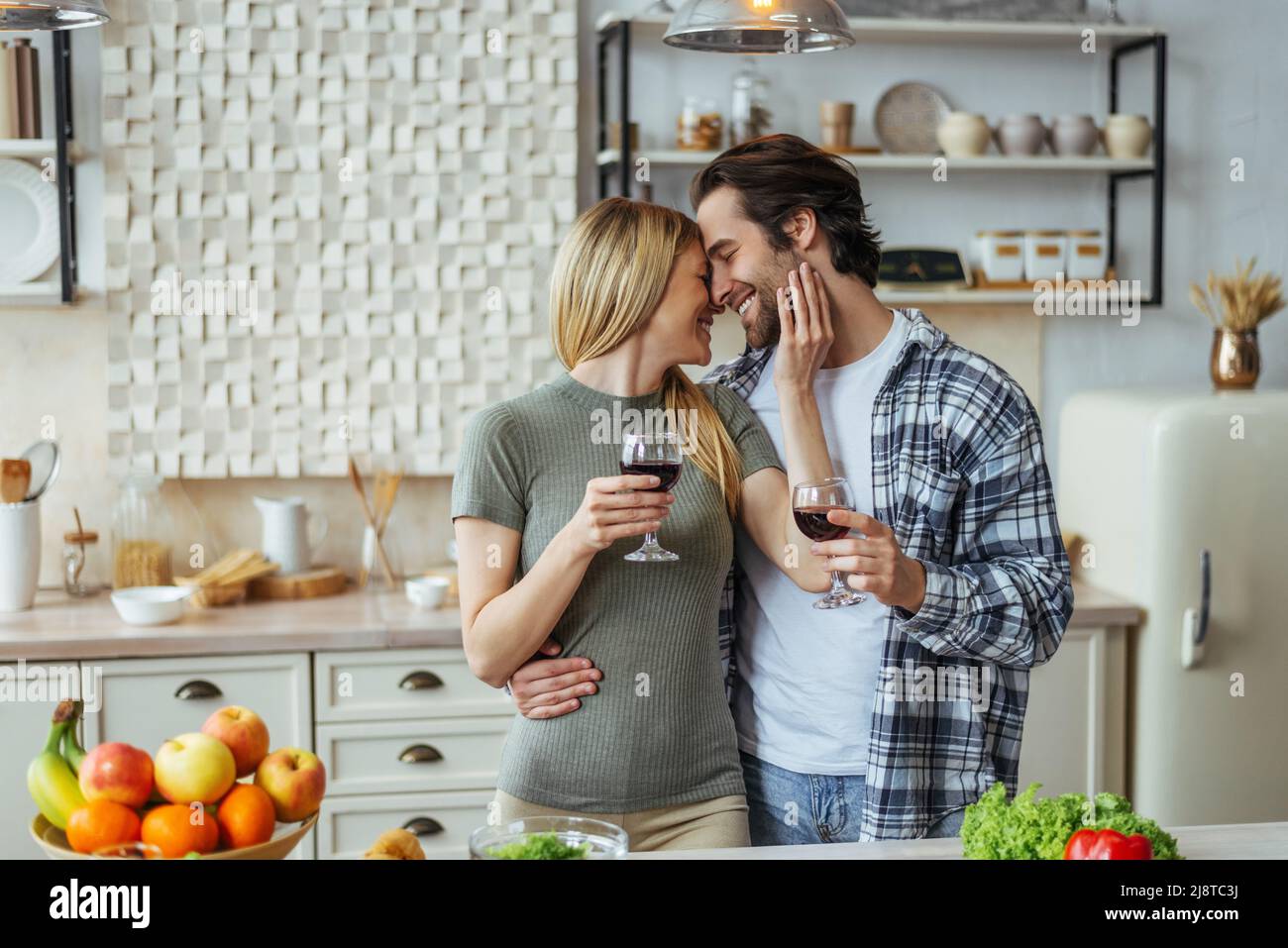 Glad Caucasian Millennial Guy With Stubble Kisses Blond Wife With Glass