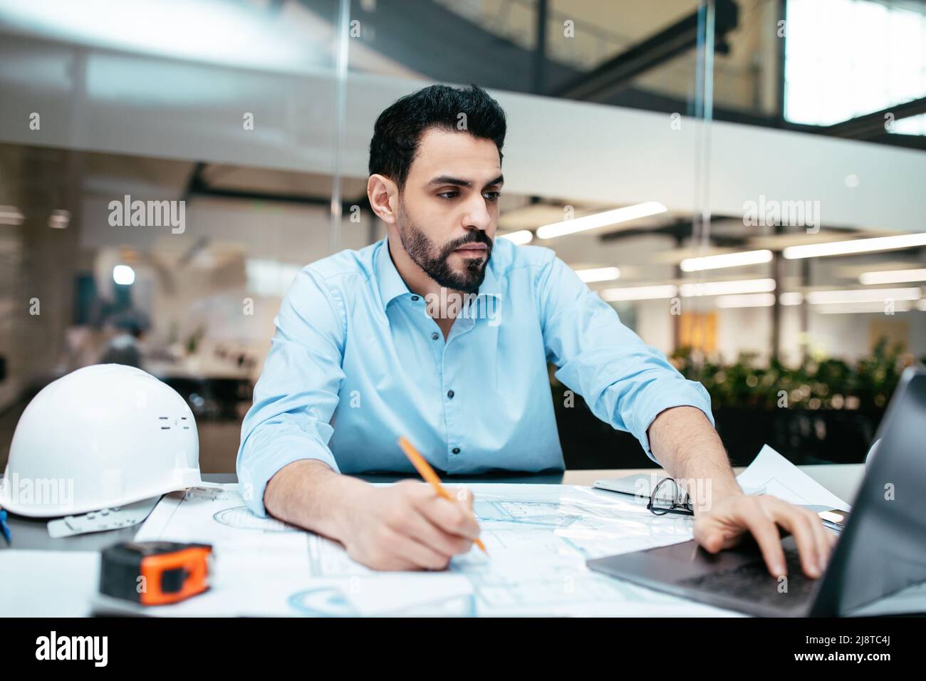 Concentrated busy handsome millennial middle eastern man architect with ...