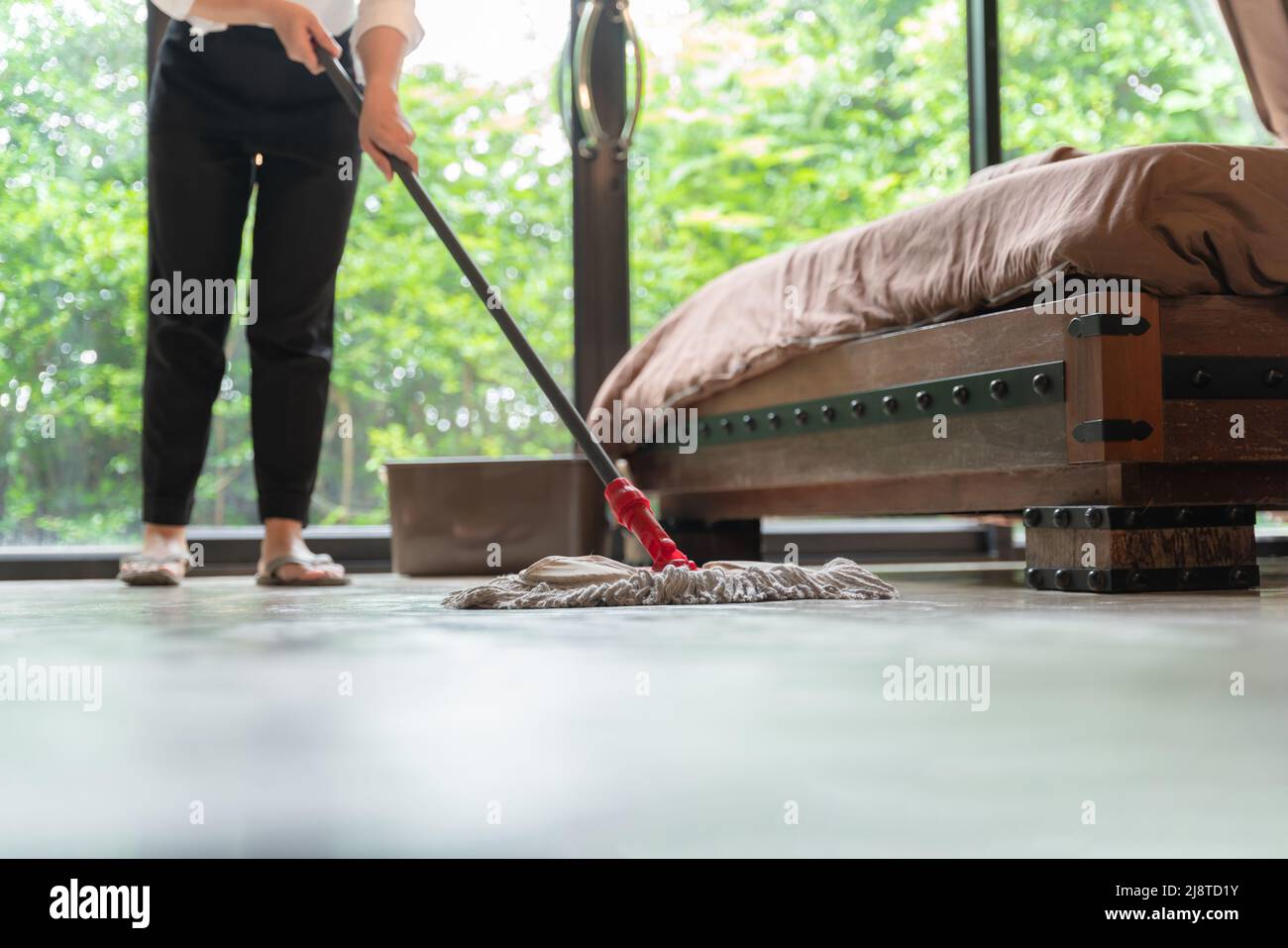 housewife using a mop in hotel room Stock Photo - Alamy