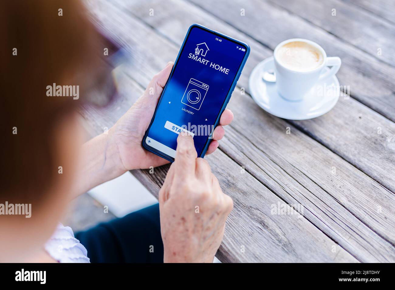 Senior woman using smart home iot app control on mobile phone to ...