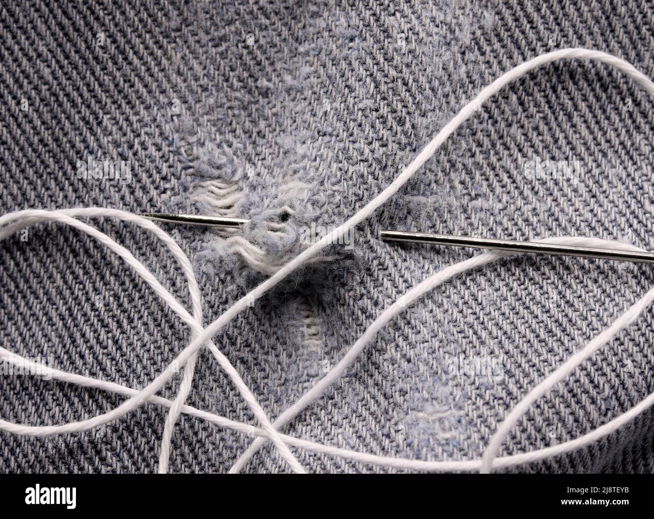 Needle and thread on fabric background Stock Photo - Alamy