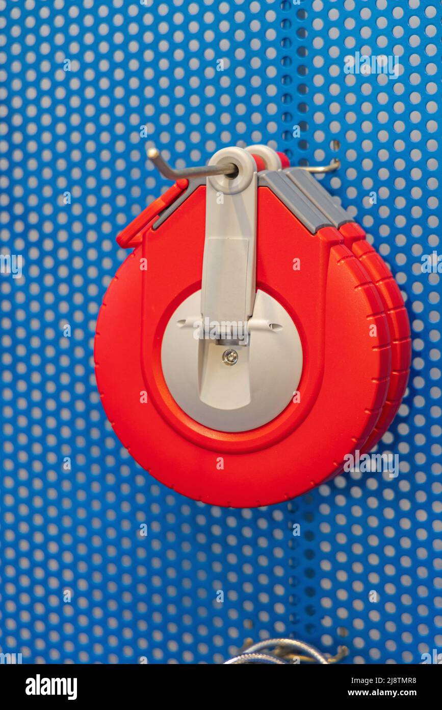Long Red Measuring Tape in Roll Device at Rack Stock Photo - Alamy