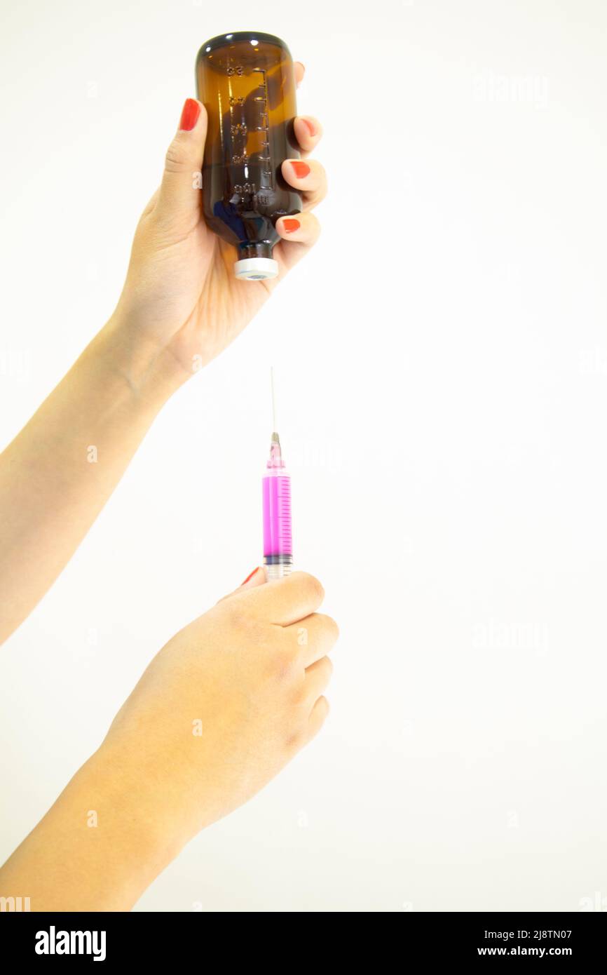 Professional laboratory technician preparing injection from amber vial ...